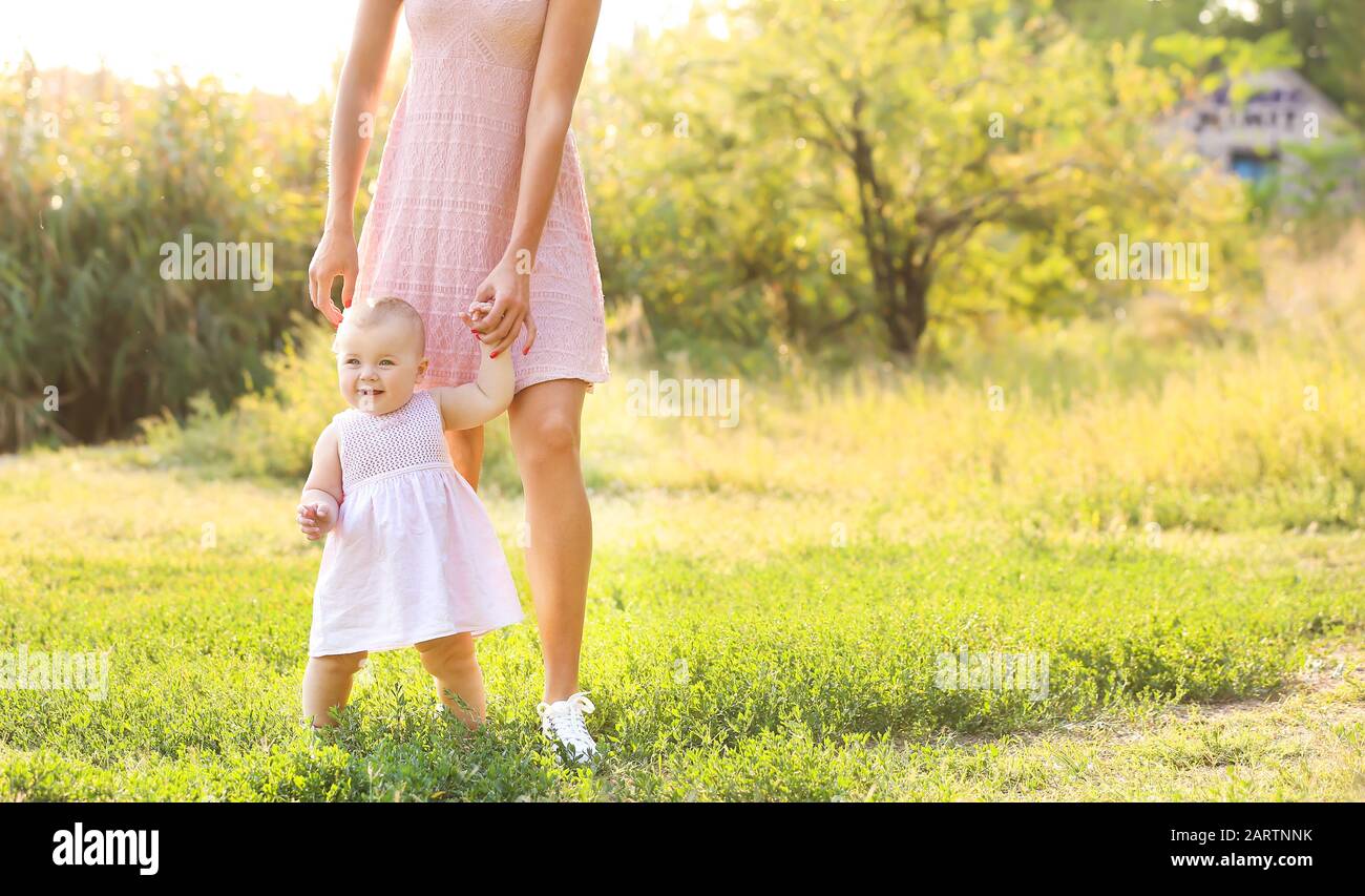 Mother teaching her little baby to walk outdoors Stock Photo - Alamy