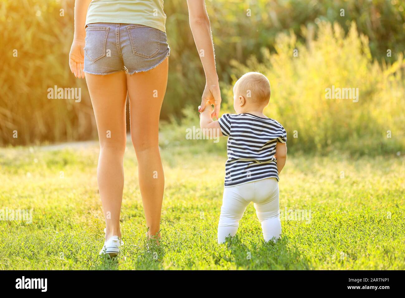 Mother teaching her little baby to walk outdoors Stock Photo - Alamy