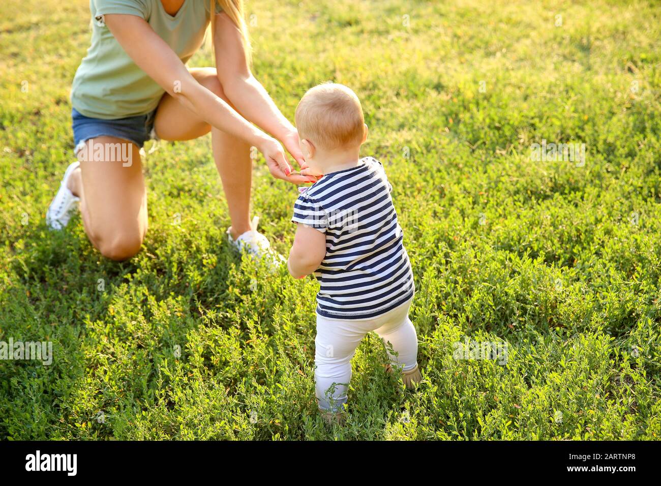 Mother teaching her little baby to walk outdoors Stock Photo - Alamy