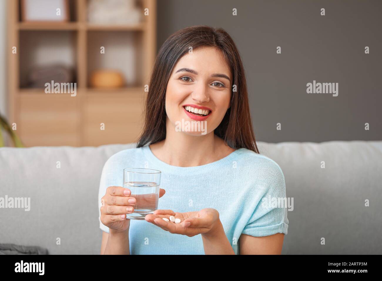Young woman taking medicine at home Stock Photo - Alamy