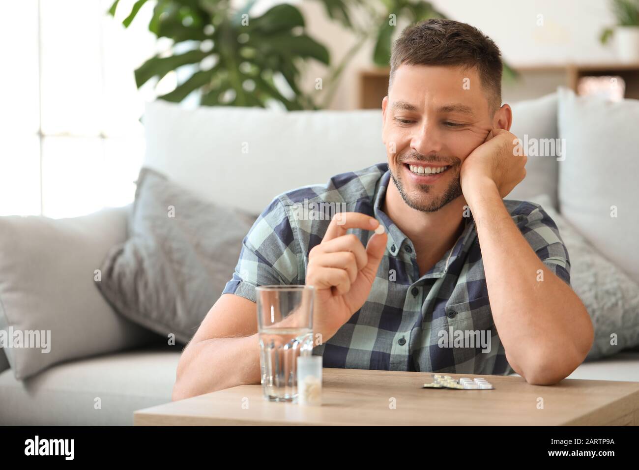 Man taking medicine at home Stock Photo - Alamy