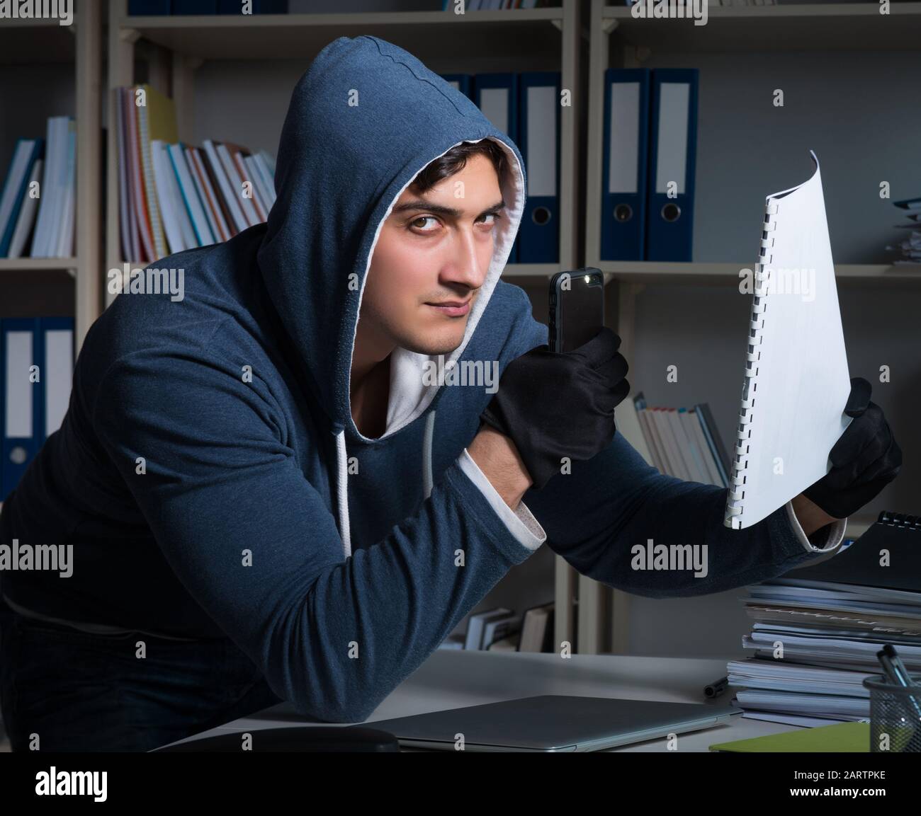 Young man in industrial espionage concept Stock Photo - Alamy