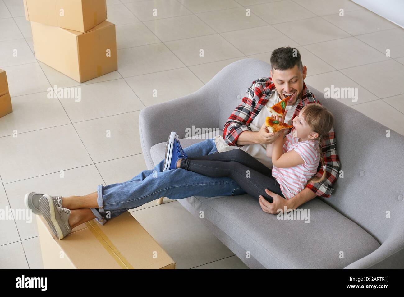 Happy father and his little daughter eating pizza on moving day Stock ...
