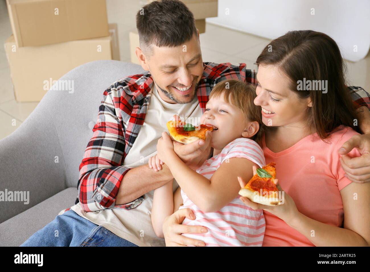 Happy family eating pizza on moving day Stock Photo - Alamy