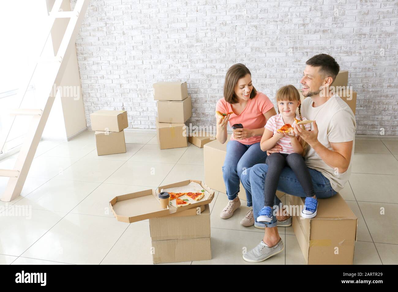 Happy family eating pizza on moving day Stock Photo - Alamy