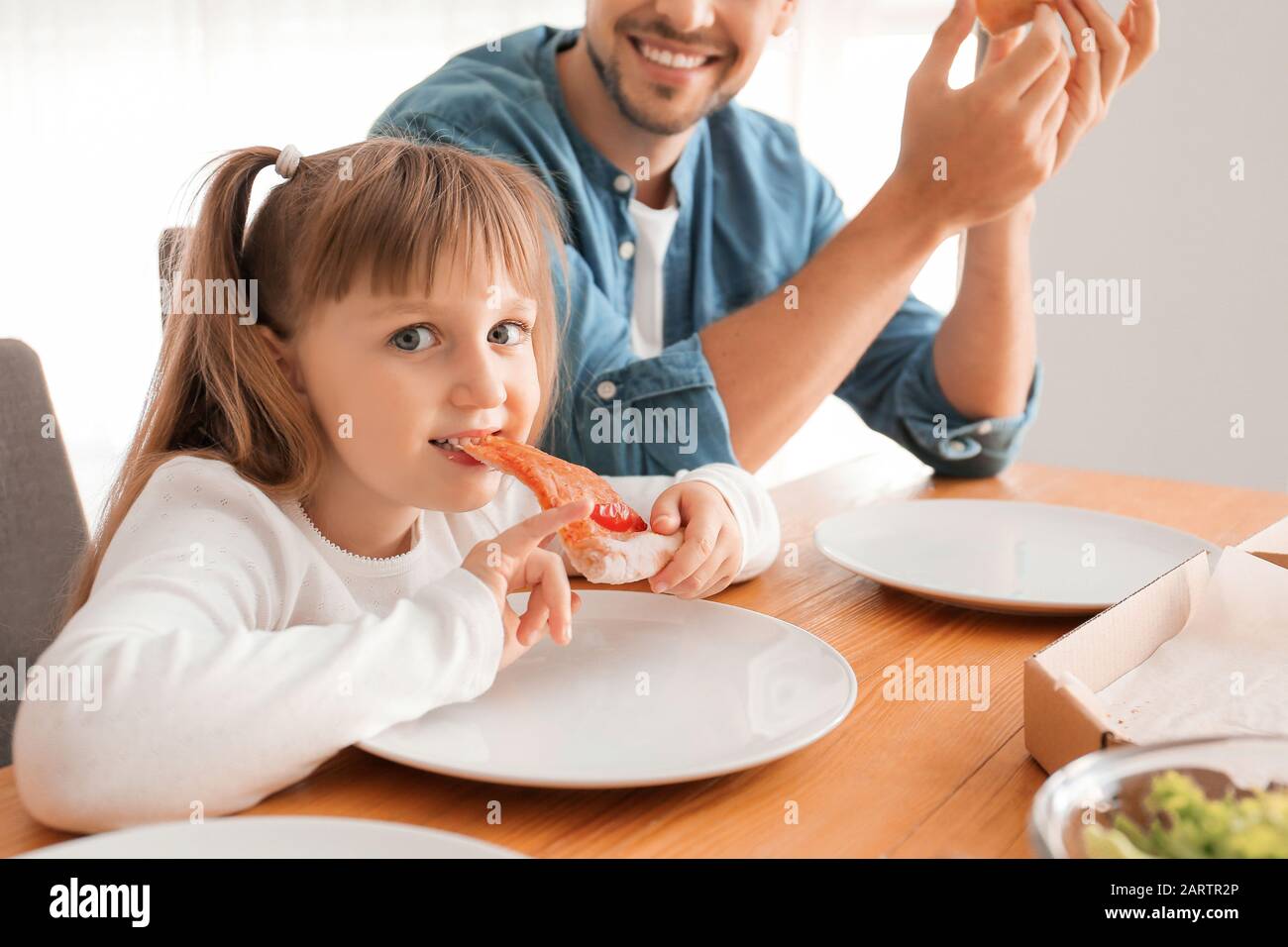 Happy father and his little daughter eating pizza at home Stock Photo ...