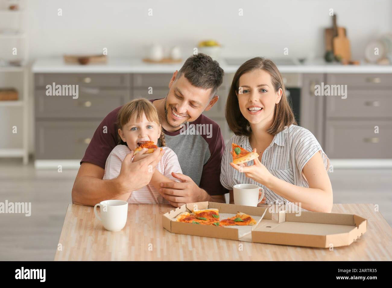 Happy family eating pizza at home Stock Photo - Alamy