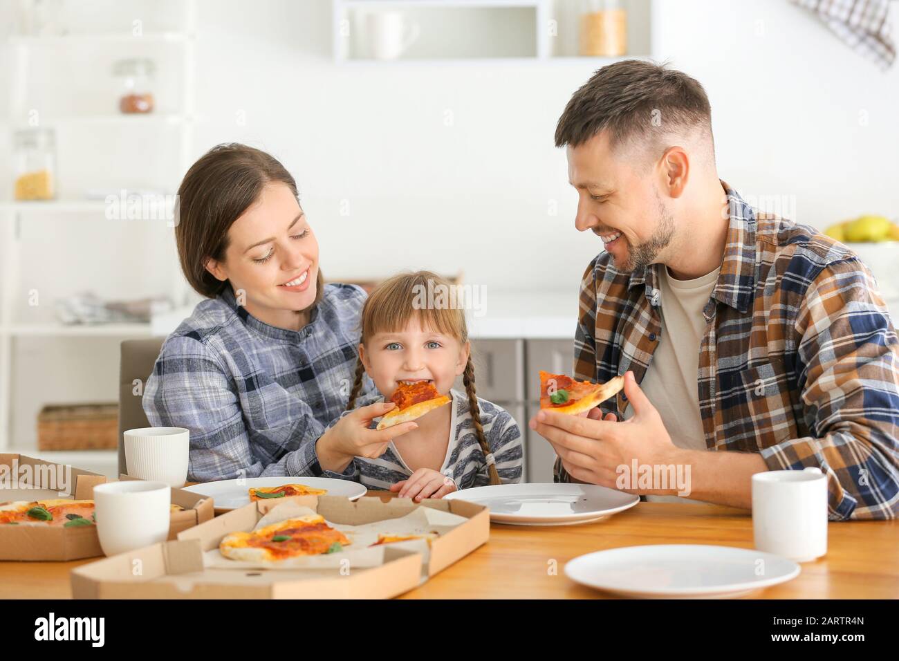 Happy family eating pizza at home Stock Photo - Alamy