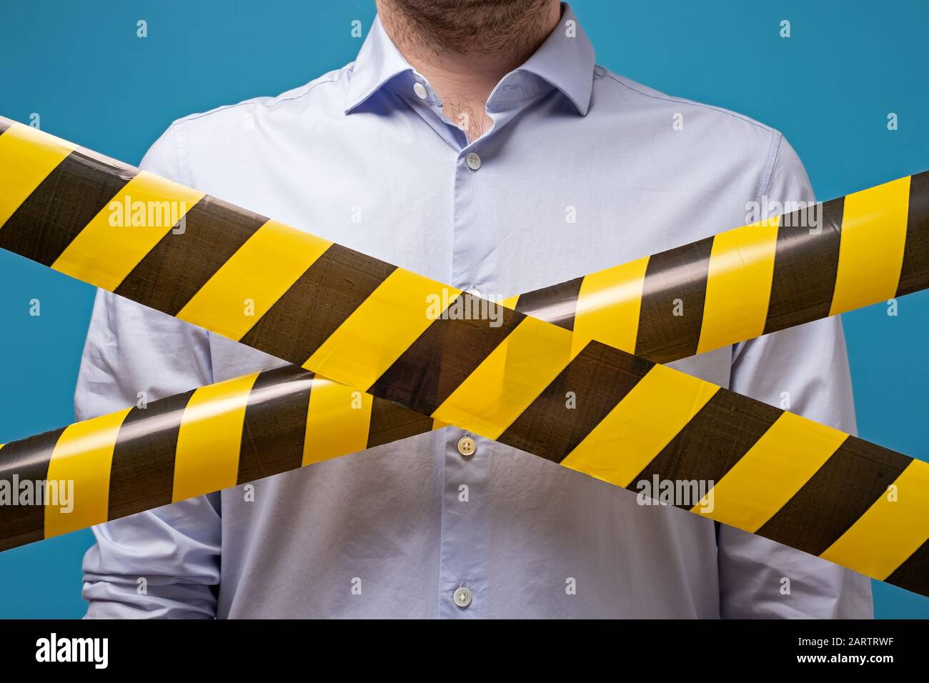 Man standing behind black and yellow lines of barrier tape that forbids ...