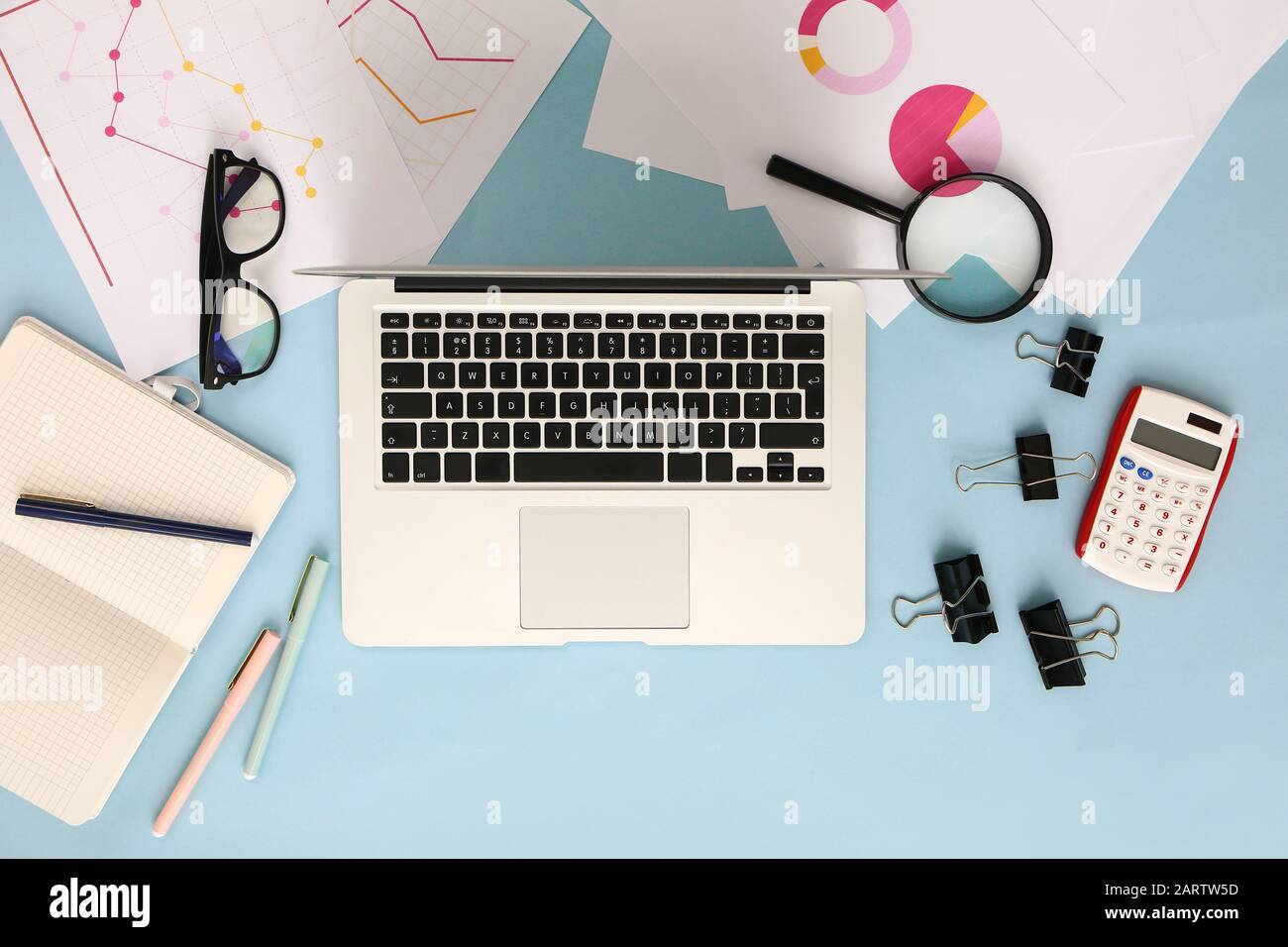 Modern laptop with calculator, documents and stationery on color ...