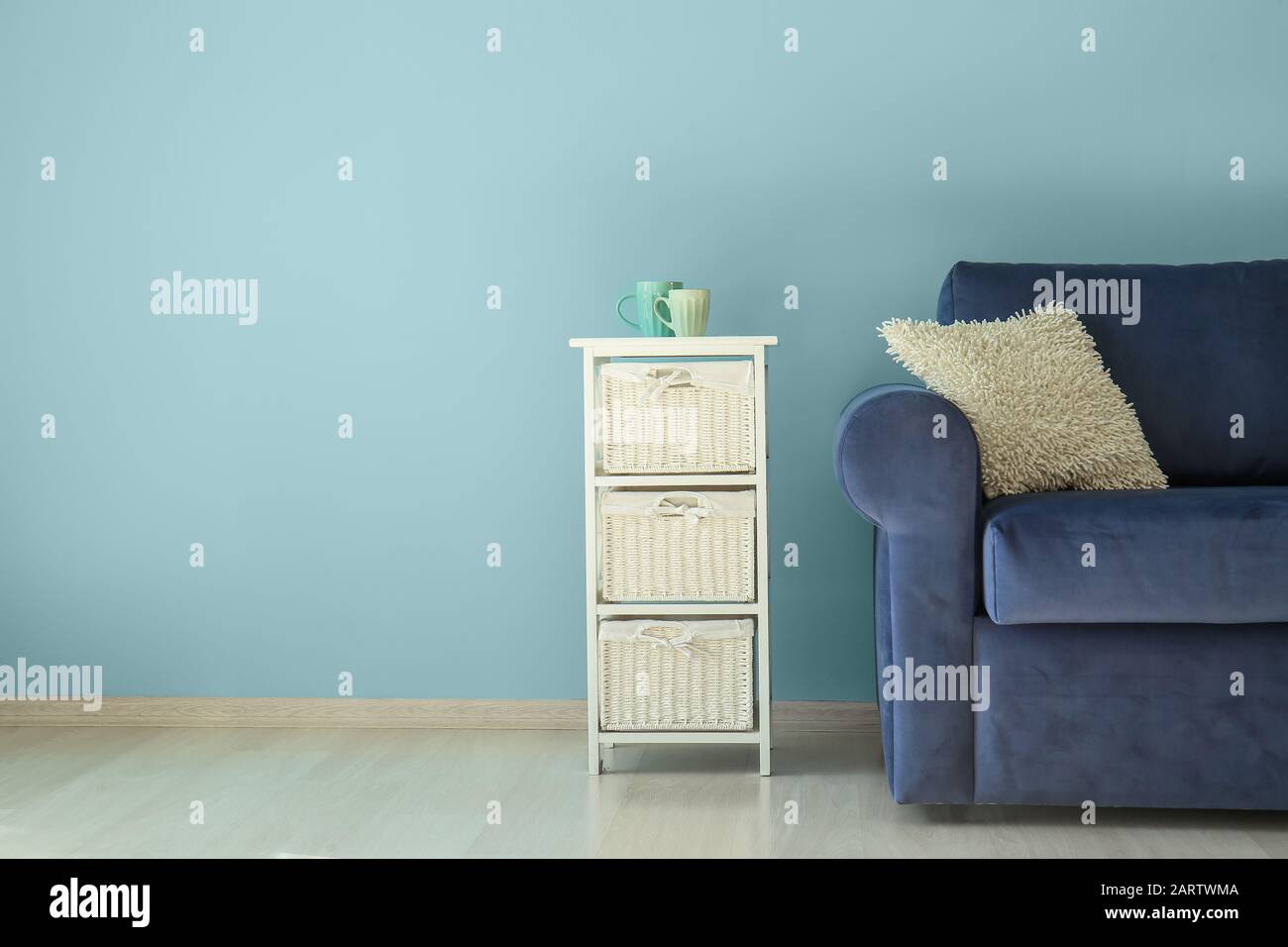 Modern sofa and stand near color wall Stock Photo - Alamy