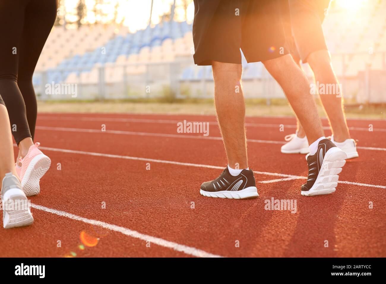 Sporty young people running at the stadium Stock Photo - Alamy