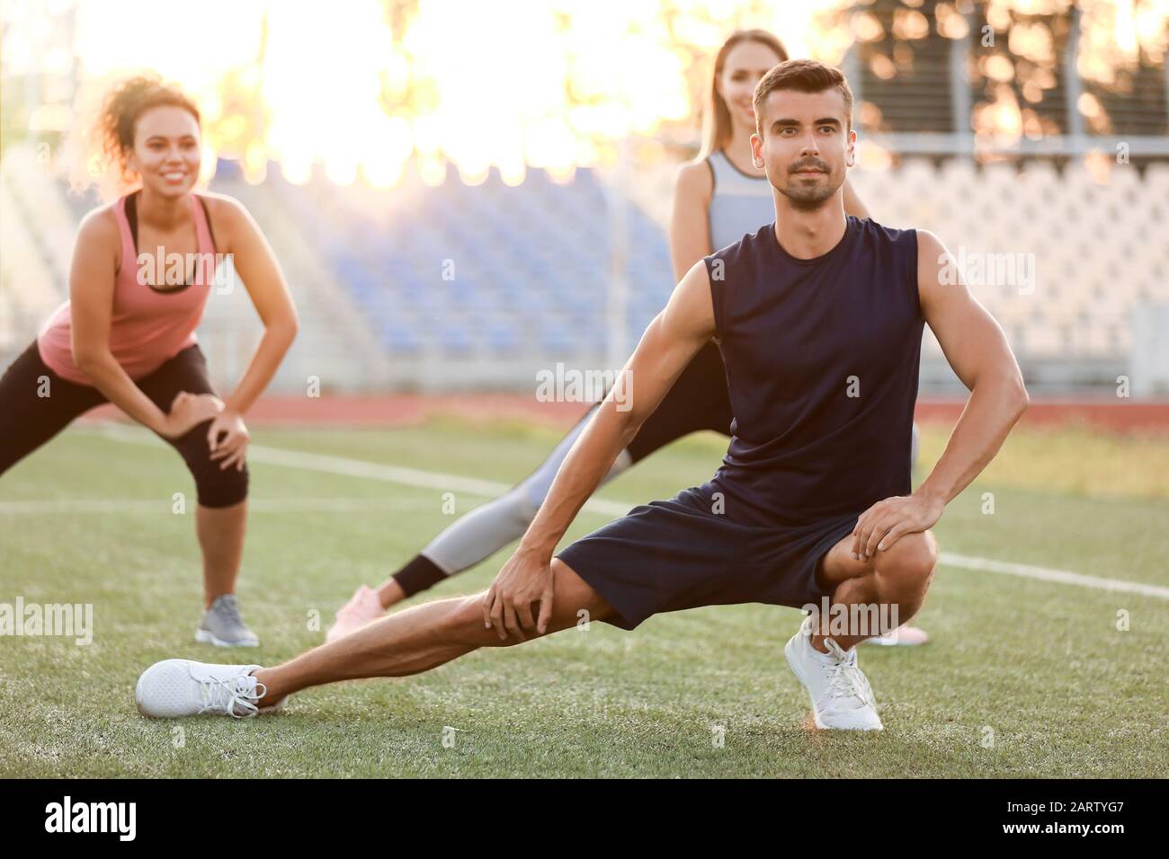 Group of sporty young people training at the stadium Stock Photo - Alamy