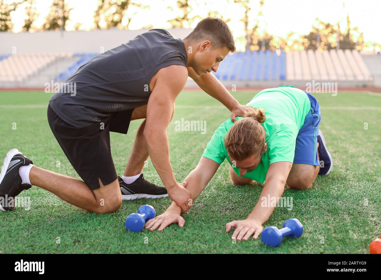 Sporty young man with coach training at the stadium Stock Photo - Alamy