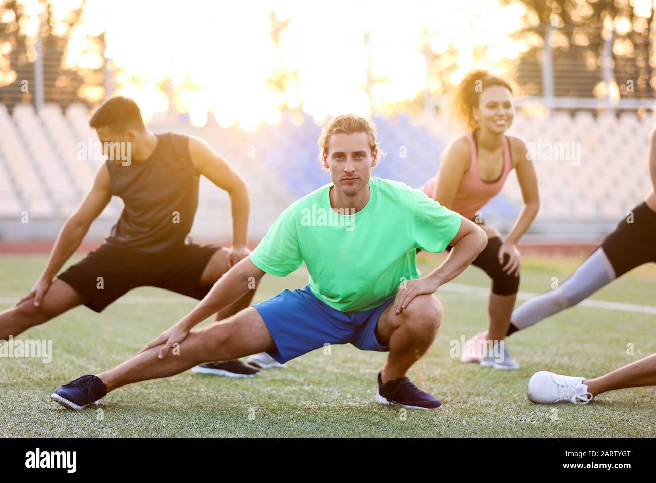 Group of sporty young people training at the stadium Stock Photo - Alamy