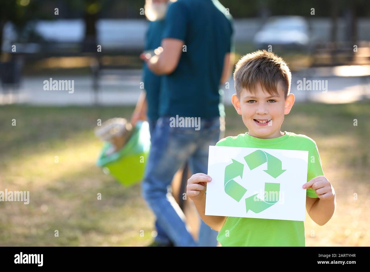 Boy holding paper sheet with symbol of recycling outdoors Stock Photo ...