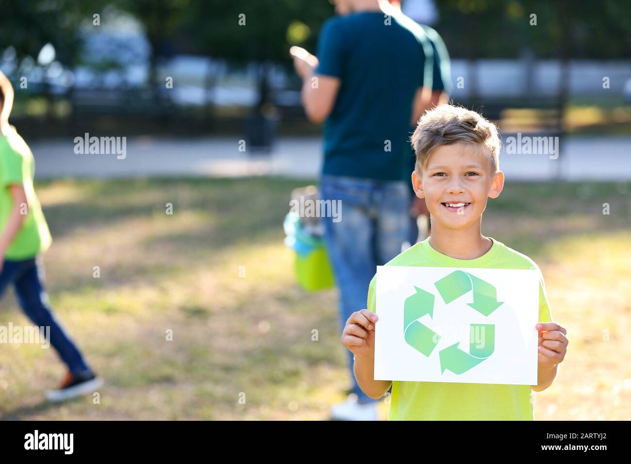 Boy holding paper sheet with symbol of recycling outdoors Stock Photo ...