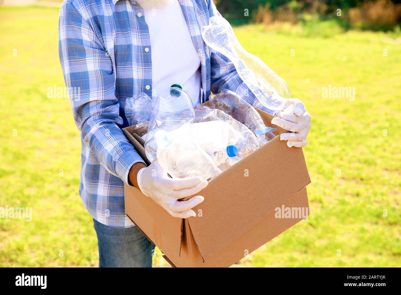 Man with gathered garbage outdoors. Concept of recycling Stock Photo ...