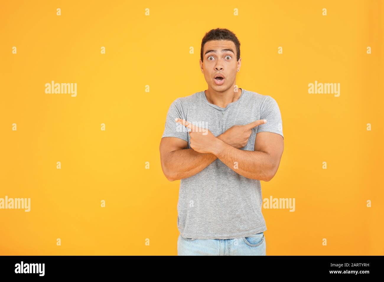 Surprised African-American man pointing in different directions on ... Surprised African-American man pointing in different directions on ...