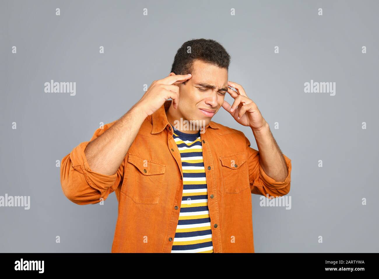 Stressed African-American man on grey background Stock Photo - Alamy
