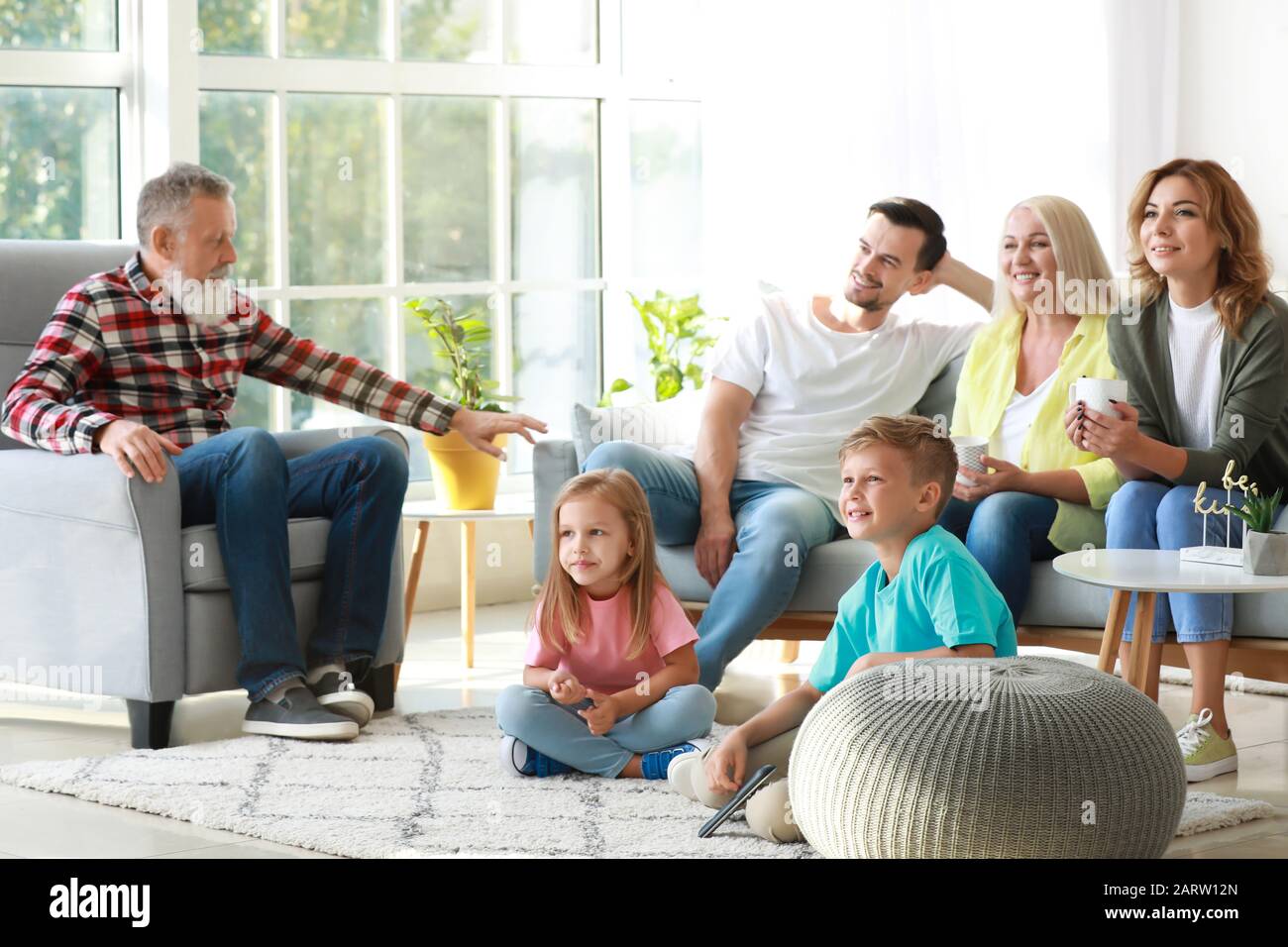 Big family watching TV together at home Stock Photo - Alamy