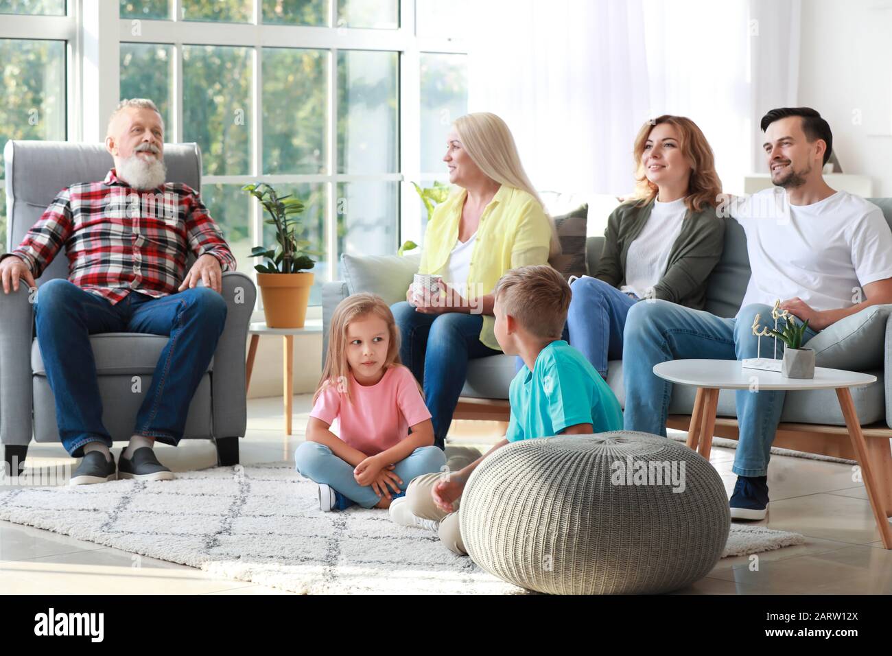 Big family watching TV together at home Stock Photo - Alamy