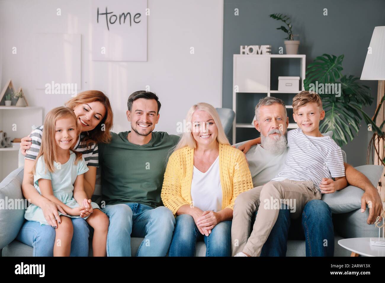 Big family sitting together on couch at home Stock Photo - Alamy