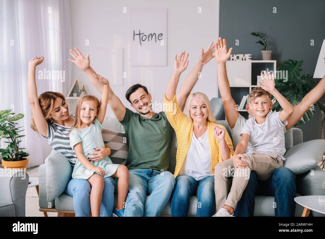 Happy family sitting together on couch at home Stock Photo - Alamy