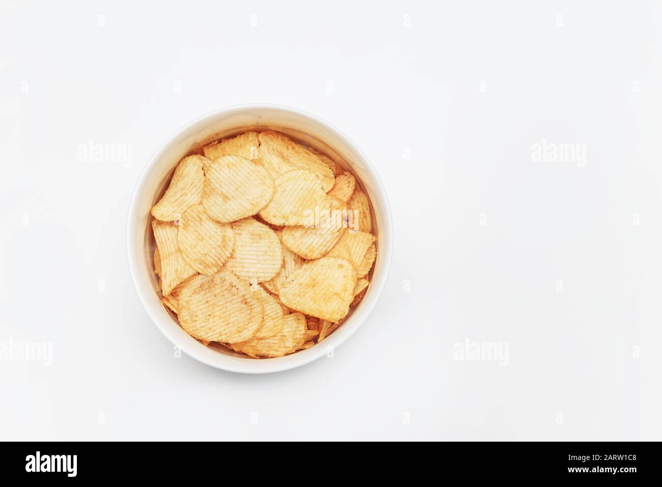 Crispy potato chips in bowl on white background, top view Stock Photo ...
