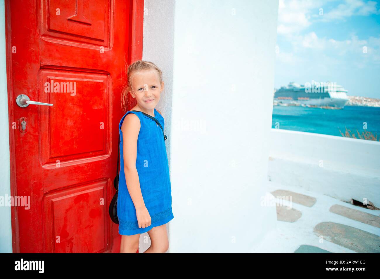 Adorable little girl at old street of typical greek traditional village ...