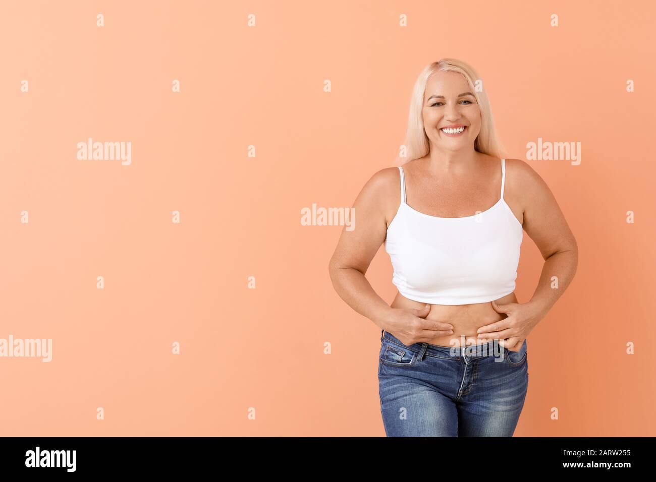 Portrait of mature body positive woman on color background Stock Photo ...