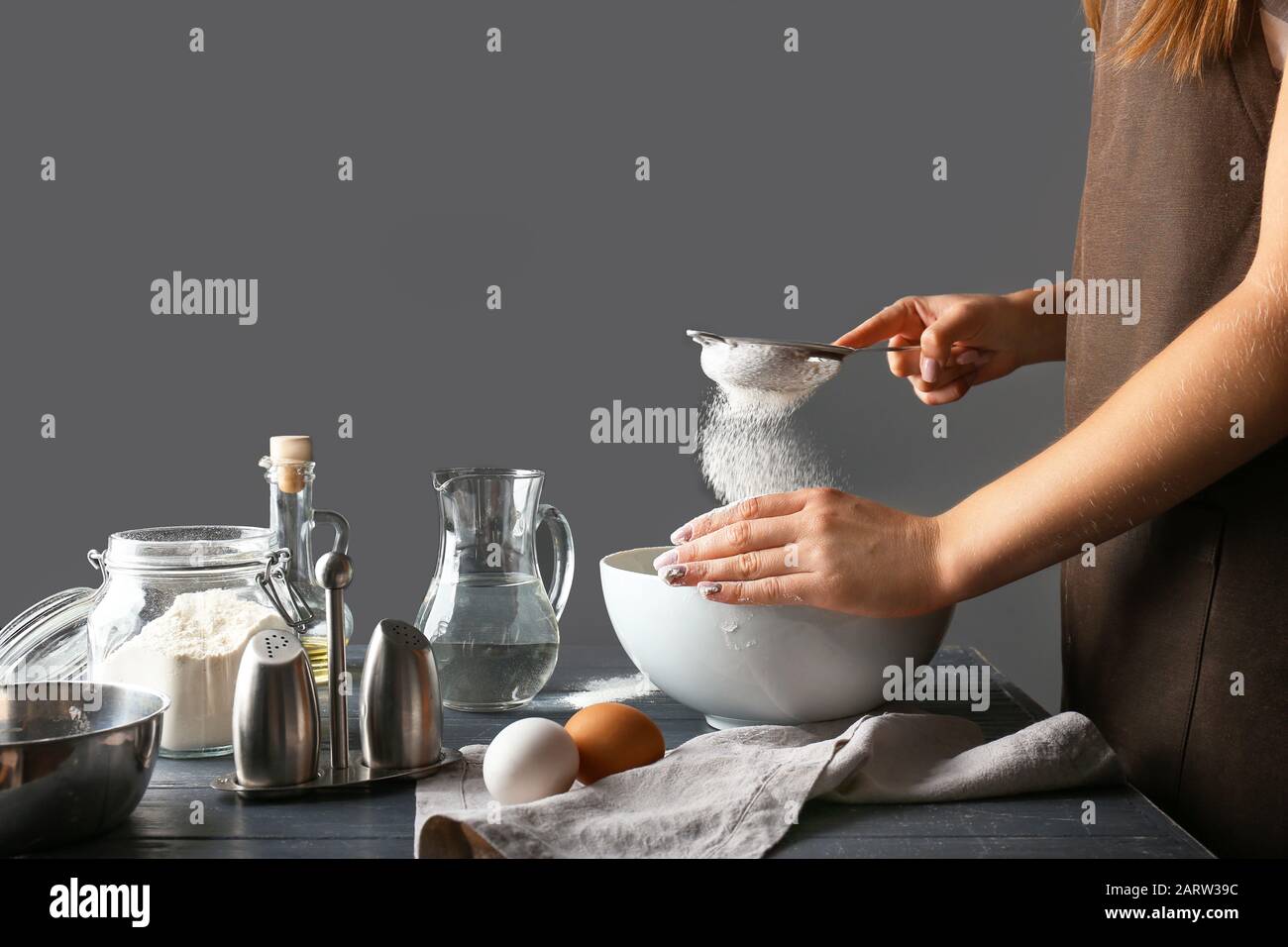 Woman sieving flour in kitchen Stock Photo - Alamy