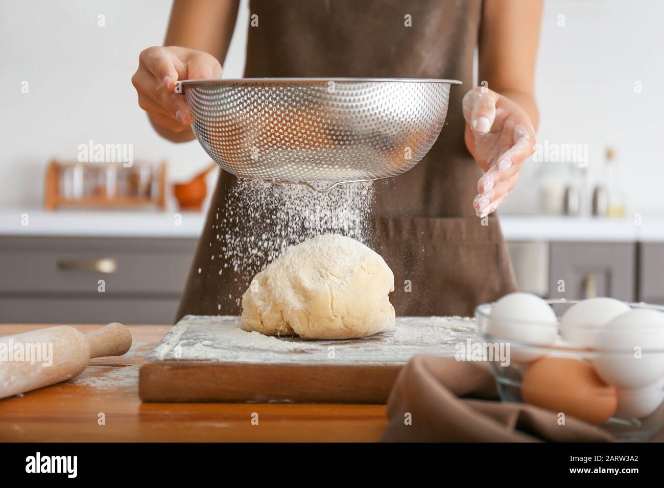 Woman sieving flour in kitchen Stock Photo - Alamy