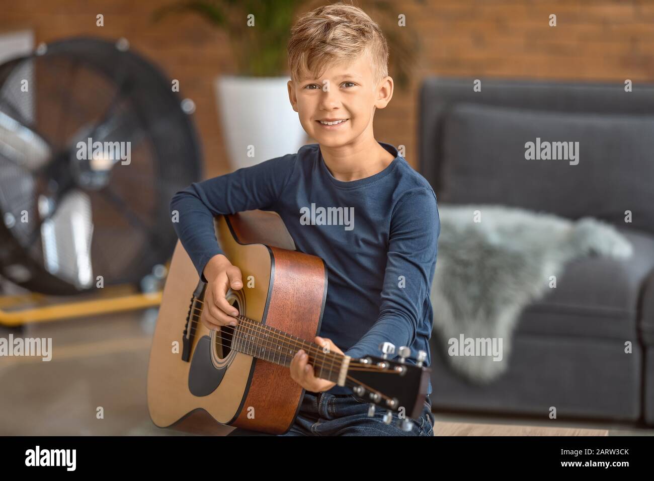 Little boy playing guitar at home Stock Photo - Alamy