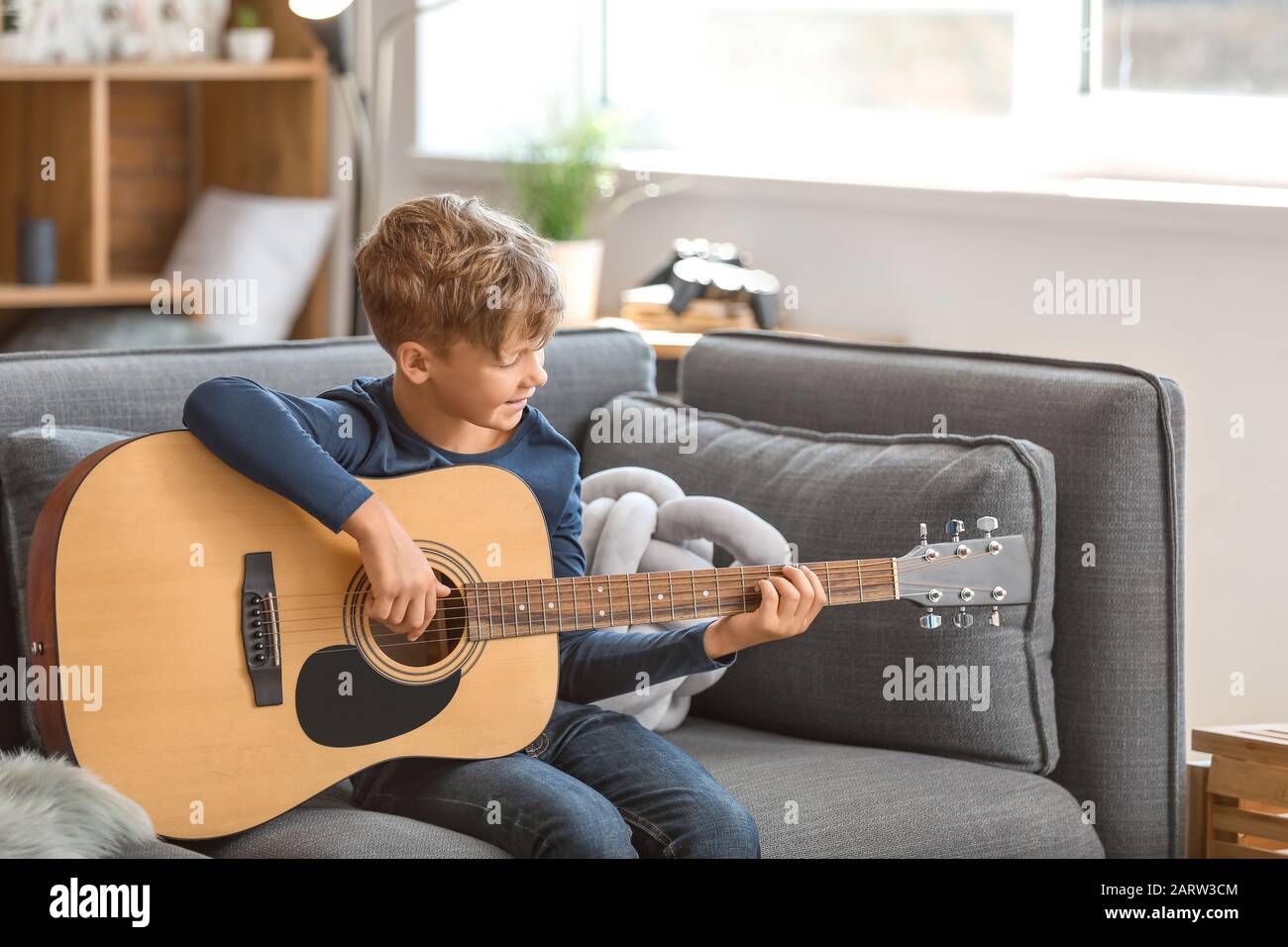 Little boy playing guitar at home Stock Photo - Alamy