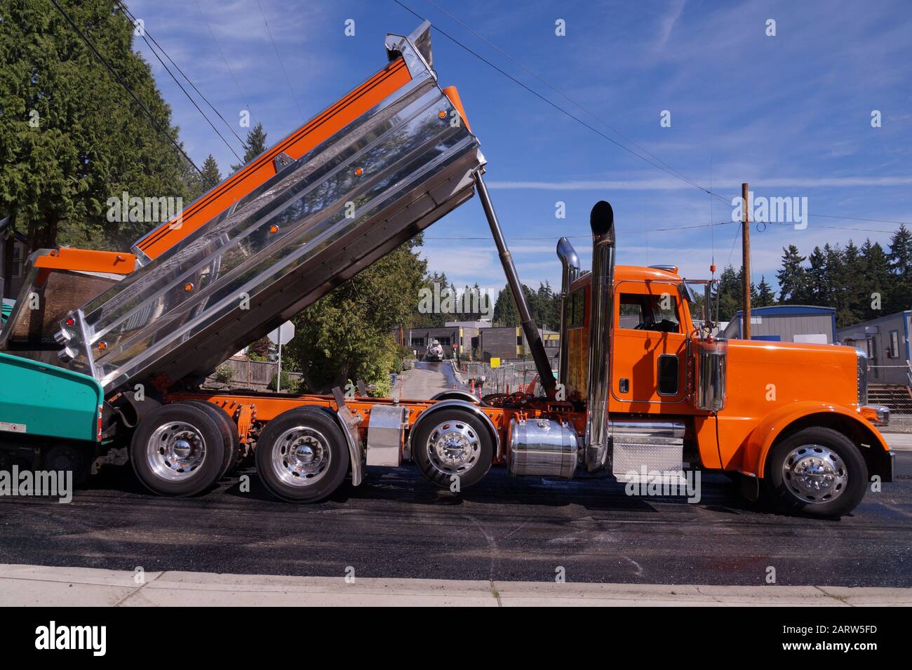 The tipper delivers another portion of asphalt. Roadworks. Laying a new ...