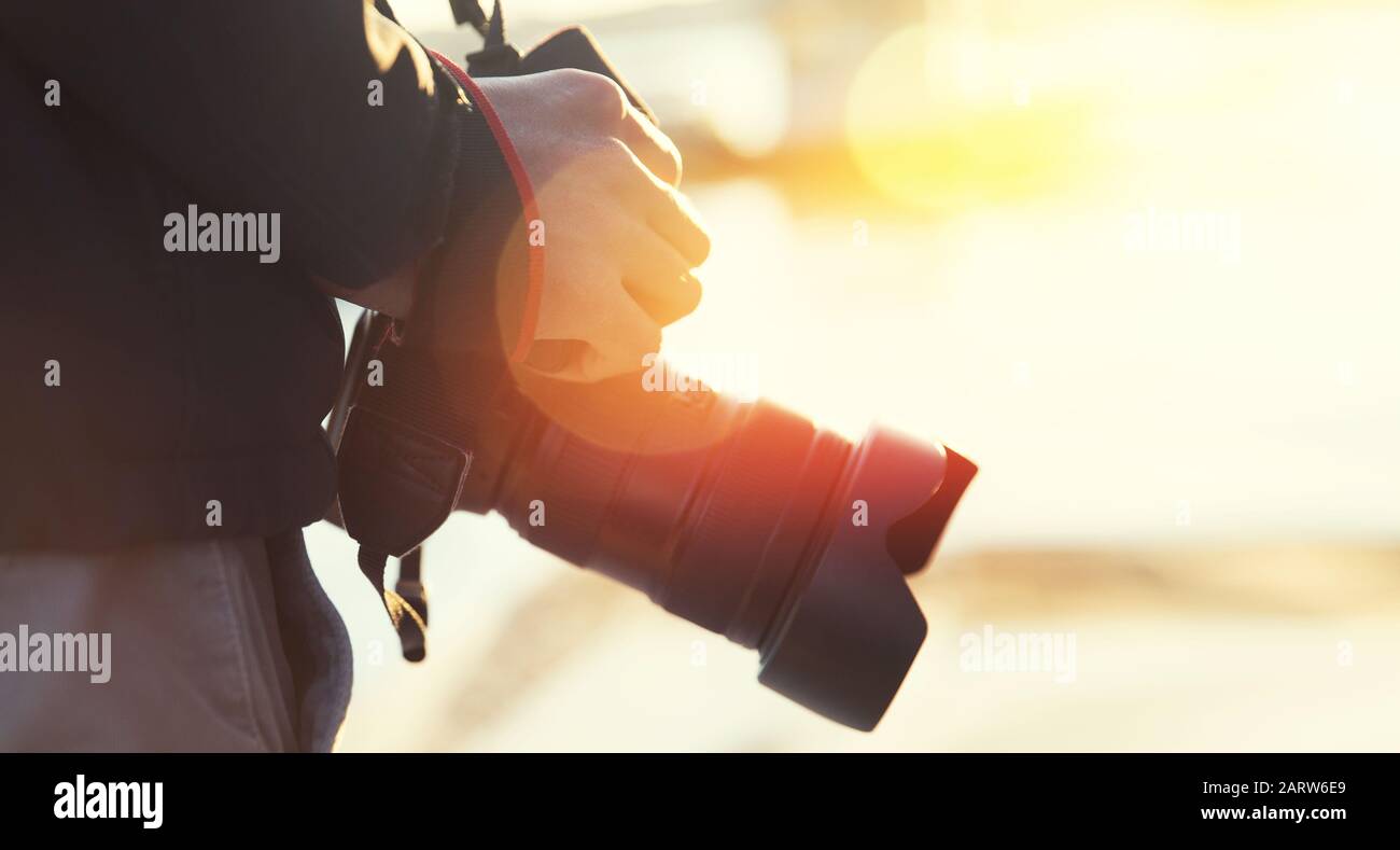 Man holds camera with hand in light sun. Concepts professional travel ...