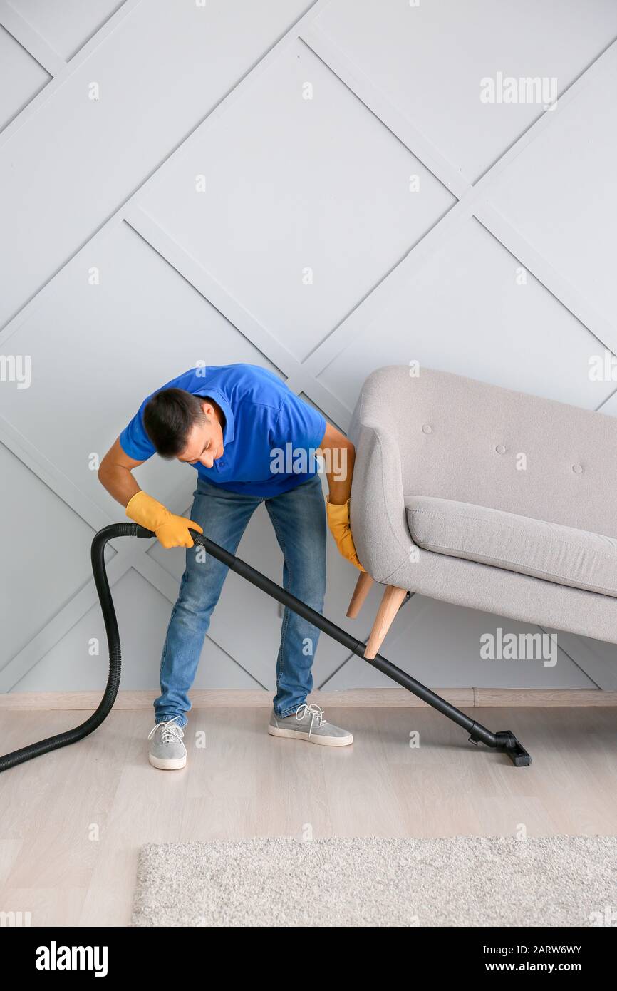 Young man cleaning his flat Stock Photo - Alamy