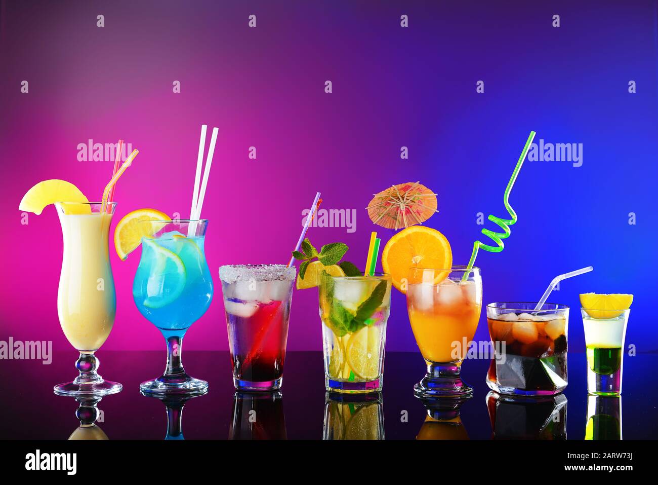 Different tasty cocktails on dark color background Stock Photo - Alamy
