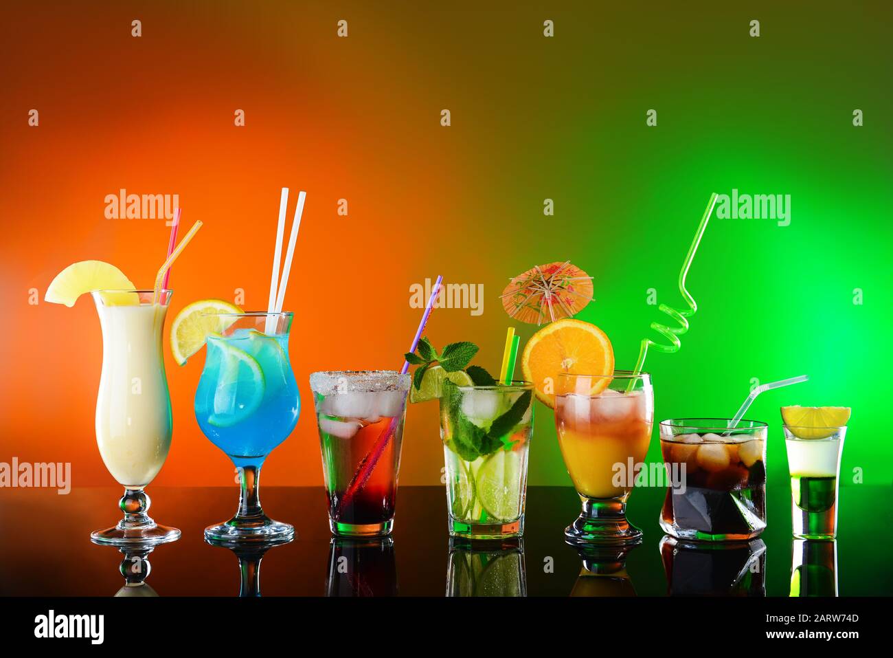 Different tasty cocktails on dark color background Stock Photo - Alamy