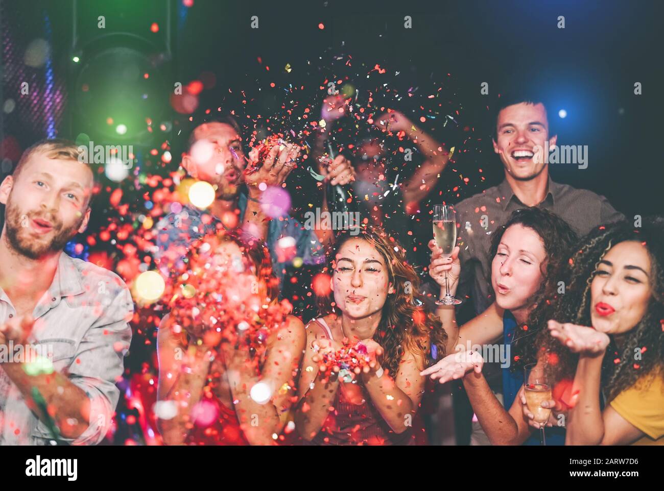 Happy friends doing party throwing confetti in nightclub - Group young ...