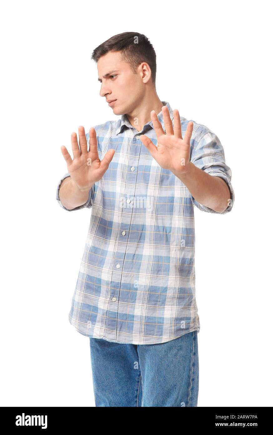 Portrait of handsome young man rejecting something on white background ...