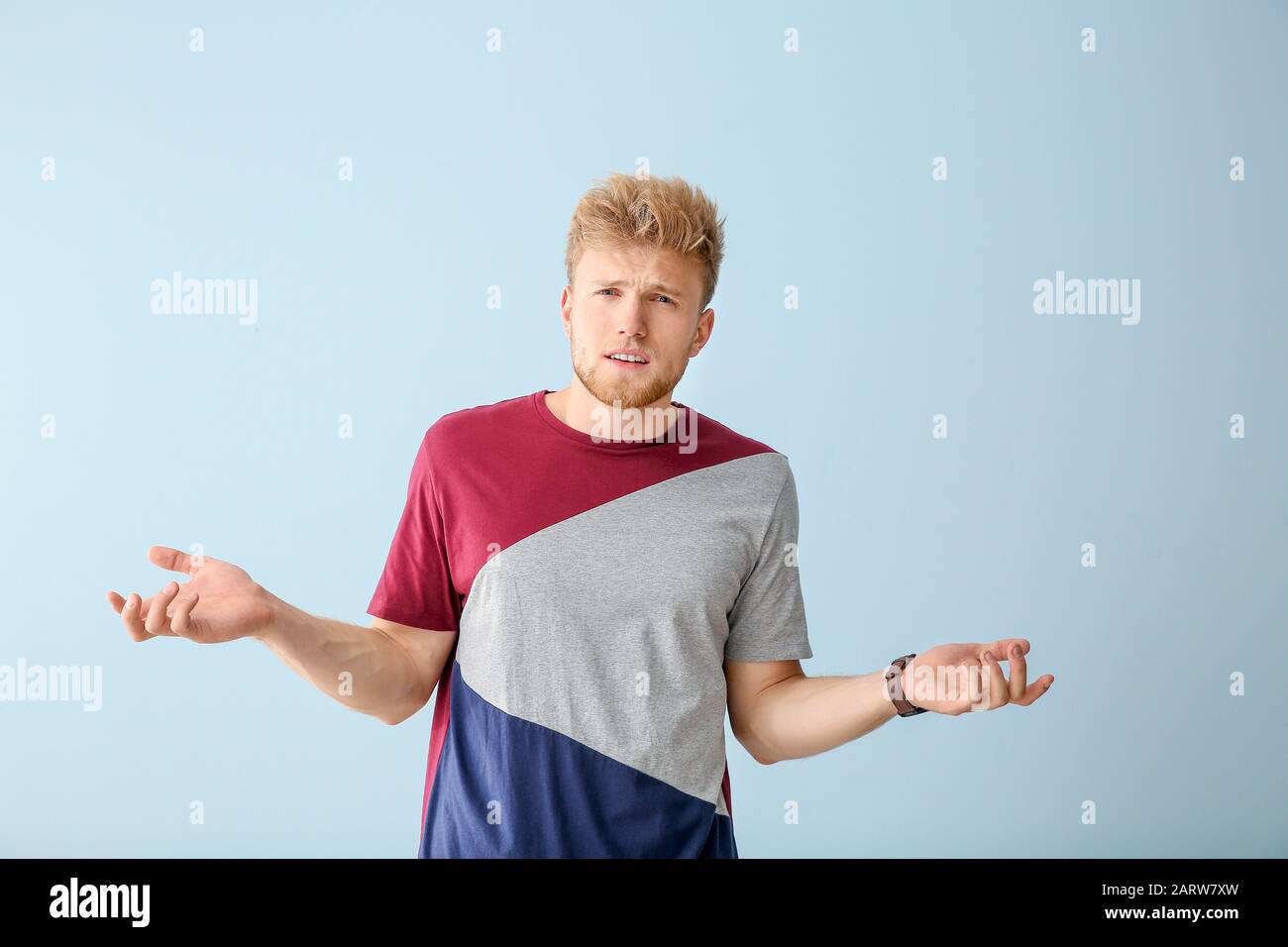Portrait of confused man on color background Stock Photo - Alamy