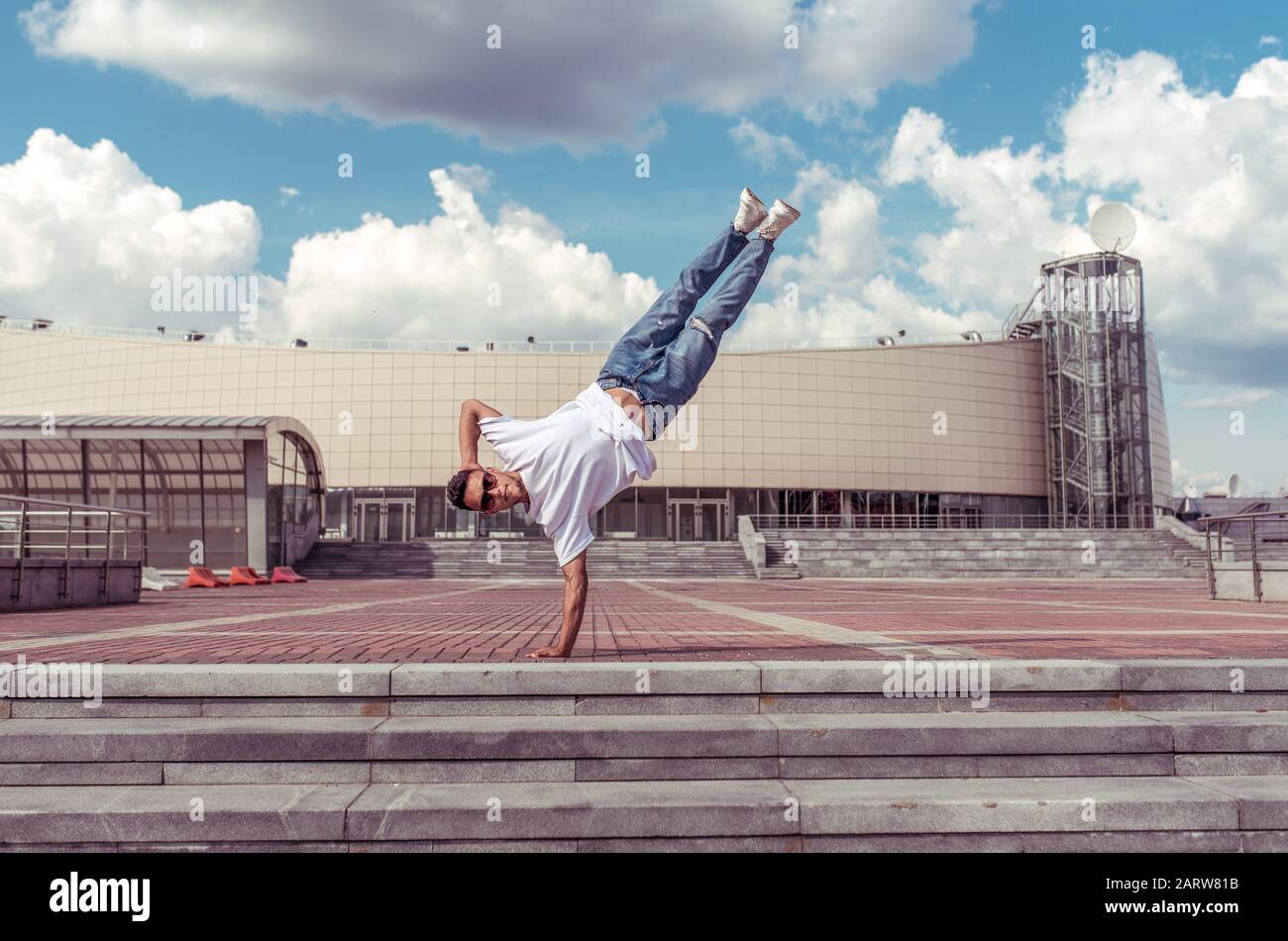 man standing on one arm, young guy dancer, summer city, dancing street ...