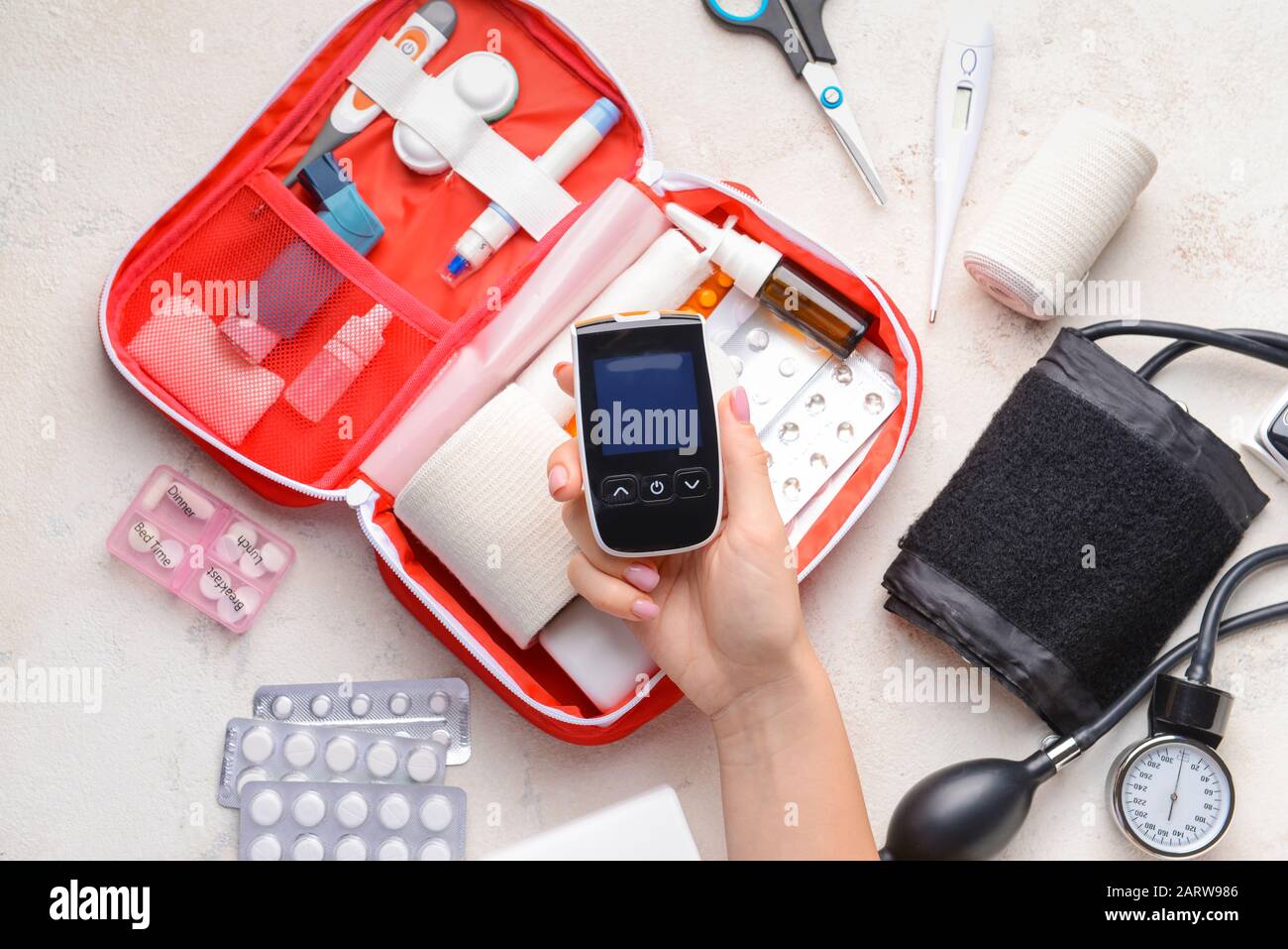 Female hand with glucometer and first aid kit on white background Stock ...