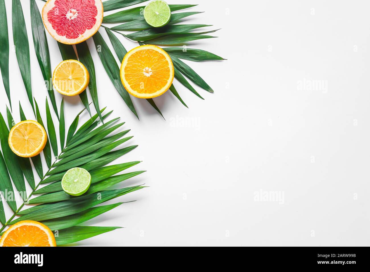 Sweet citrus fruits with tropical leaves on white background Stock ...