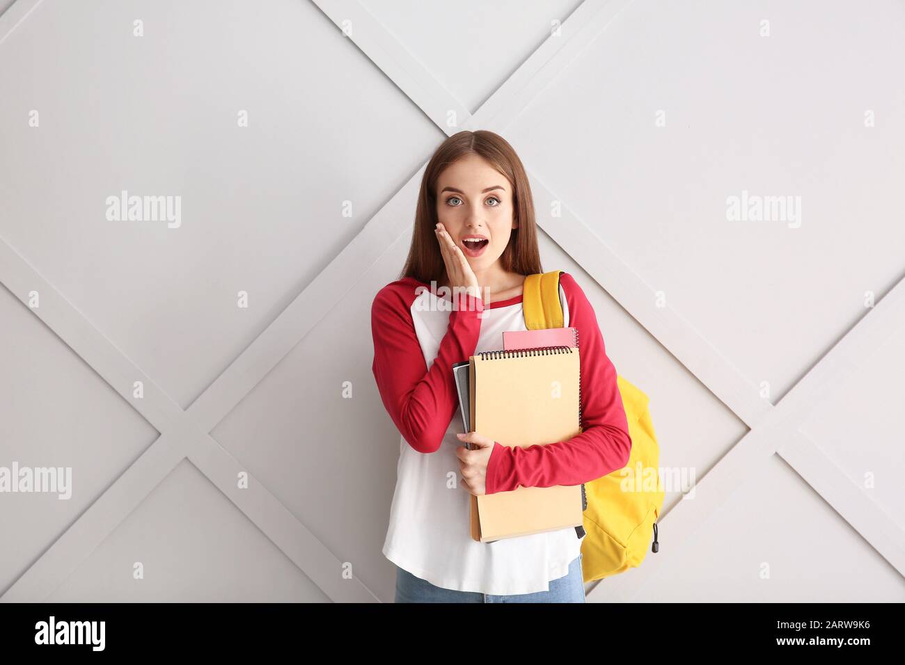 Shocked female student on light background Stock Photo - Alamy