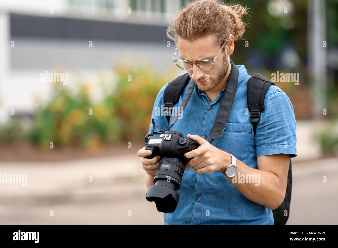 Young male photographer with camera outdoors Stock Photo - Alamy