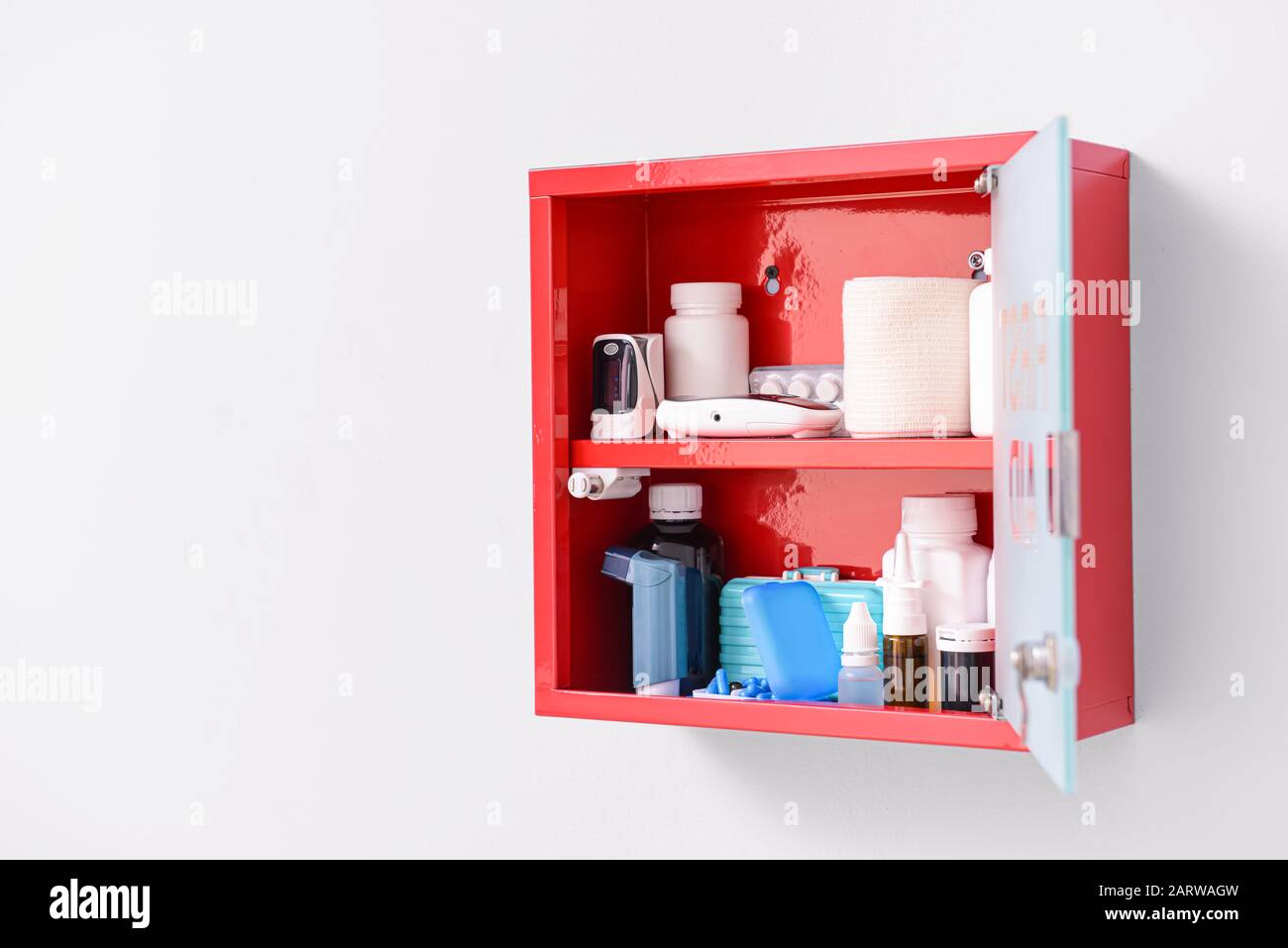 Wall mounted first aid kit on light background Stock Photo - Alamy