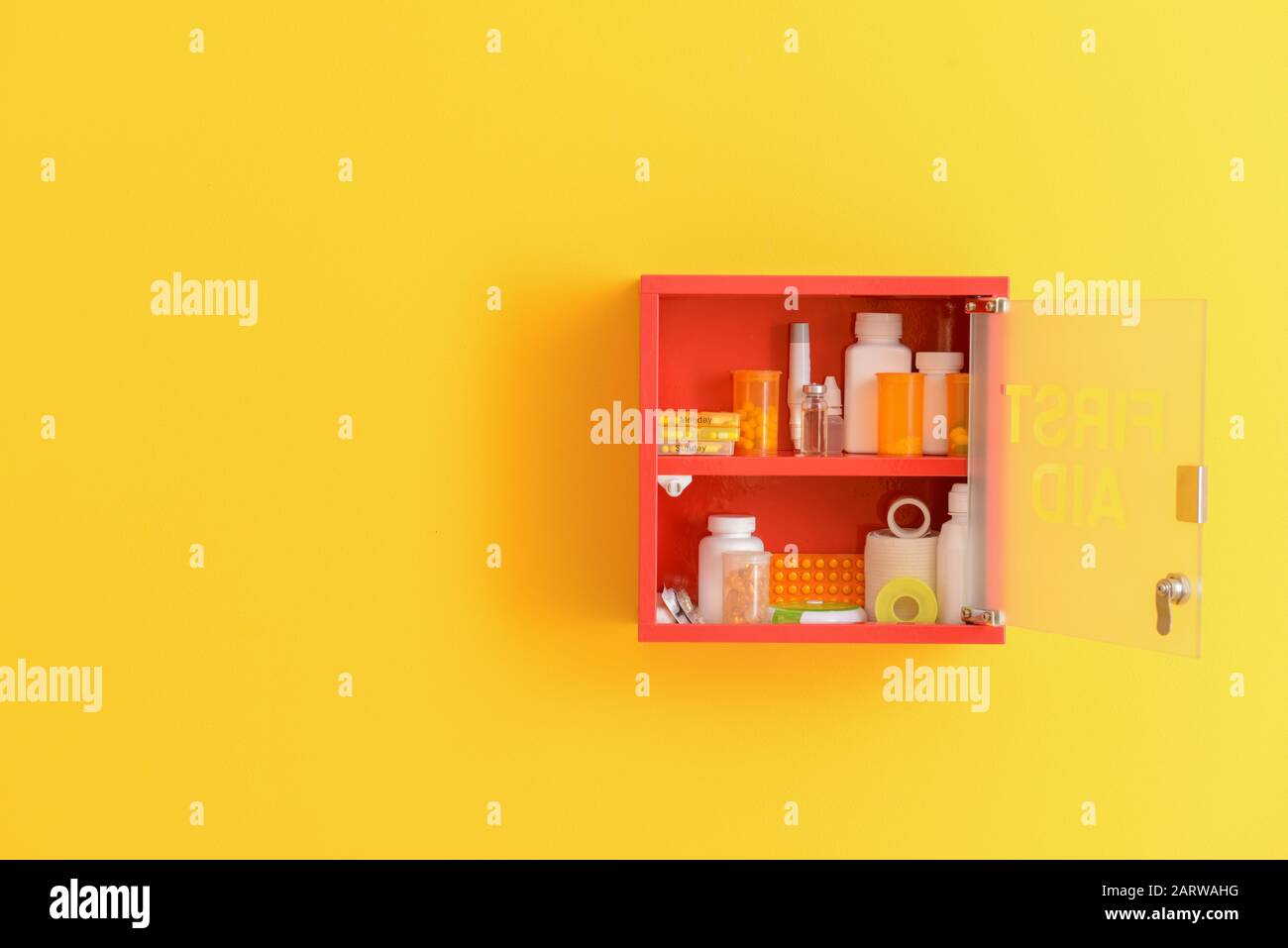 First aid kit hanging on color wall Stock Photo - Alamy